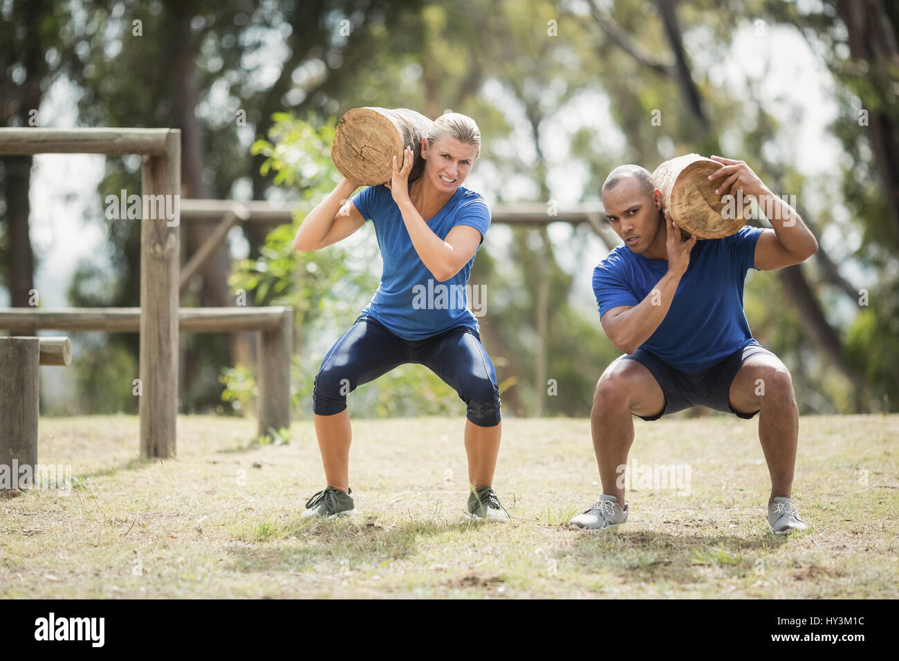 People carrying heavy wooden logs during obstacle course in boot camp ...