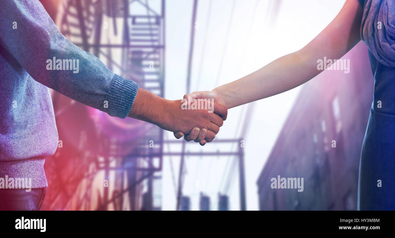 Partners shaking hands against electric cables and building exterior ...
