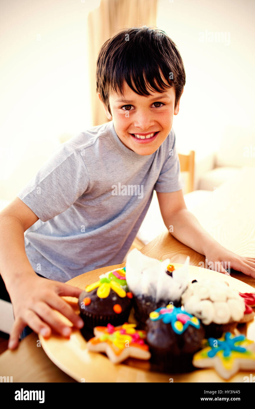 Happy boy eating colorful confectionery at home Stock Photo - Alamy