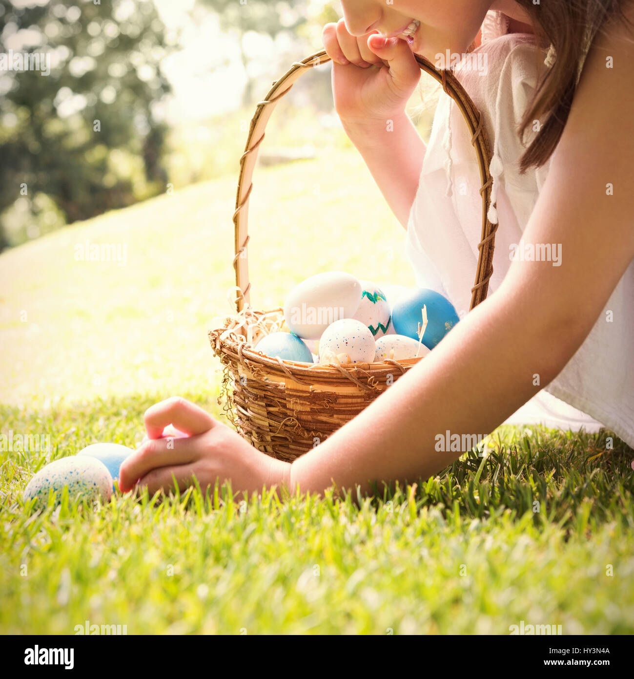 Little girl collecting easter eggs outside in the garden Stock Photo ...