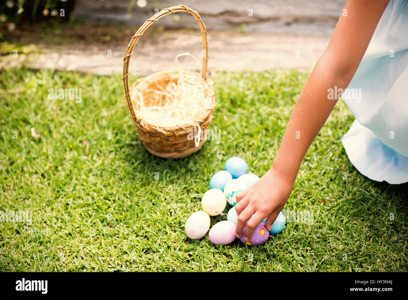 Little girl collecting easter eggs in the garden Stock Photo - Alamy