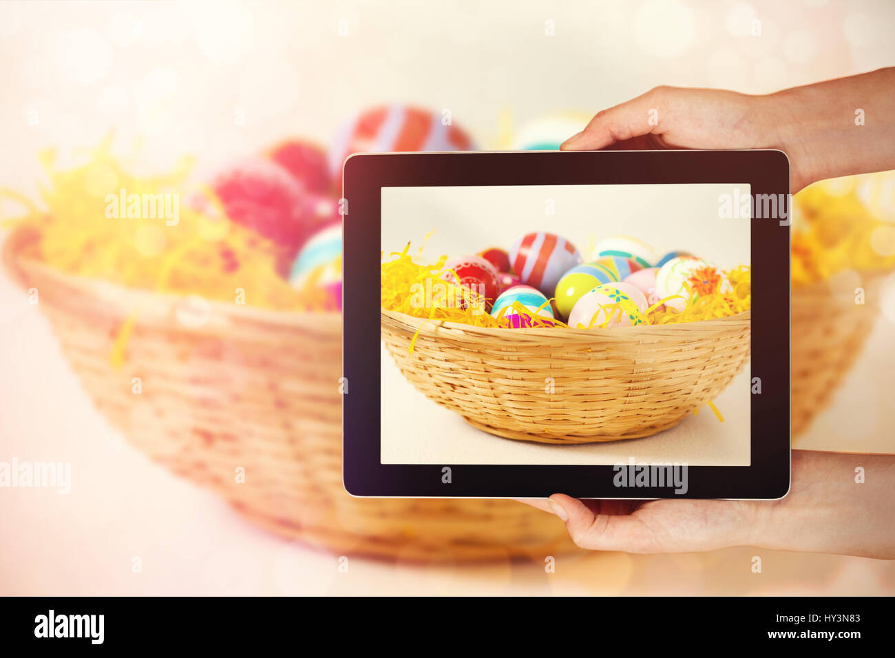 Close-up of hands holding digital tablet against painted easter eggs in ...