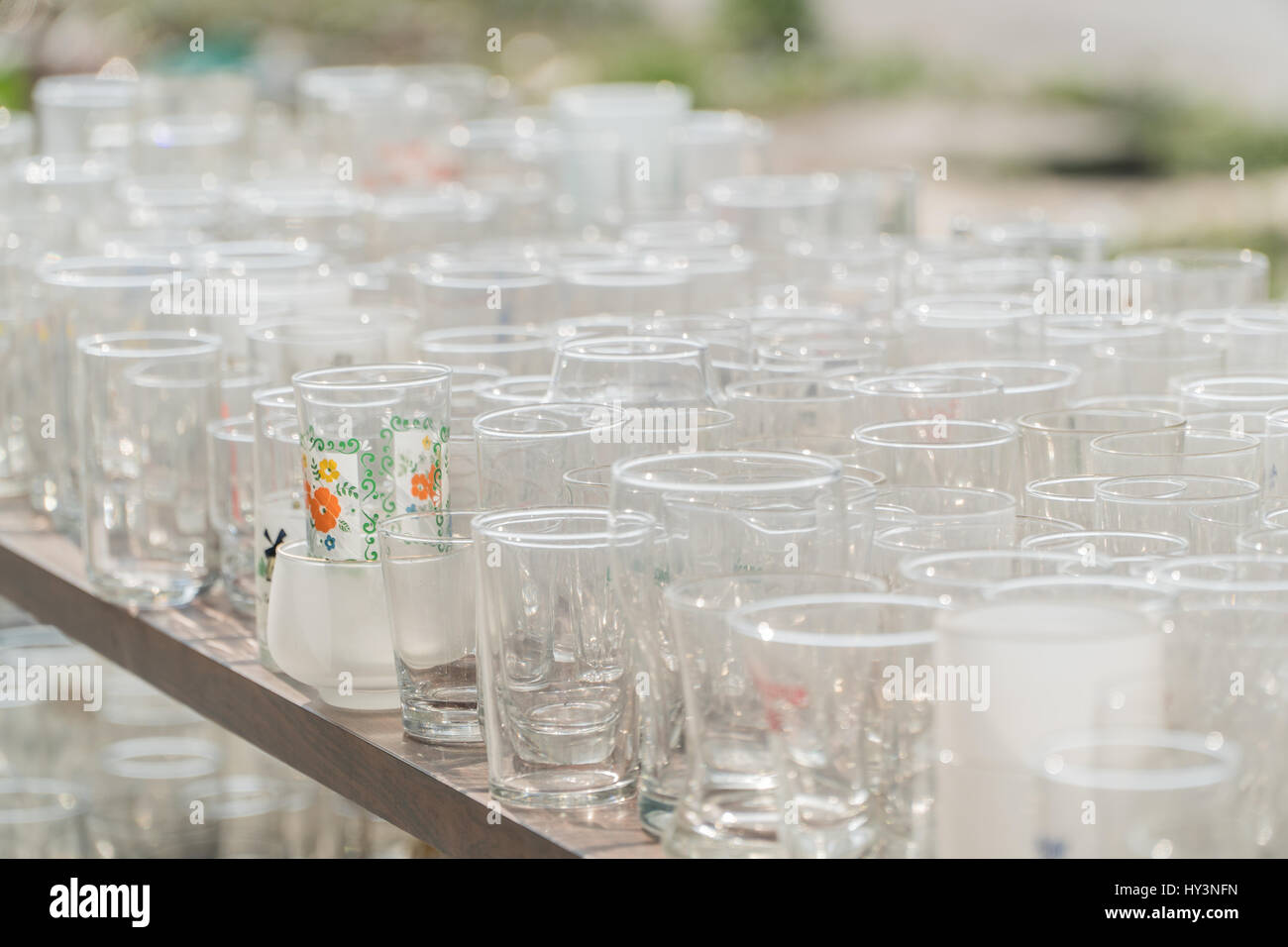 Lots of clean empty glasses of drinks on the bar in a nightclub. Glare ...