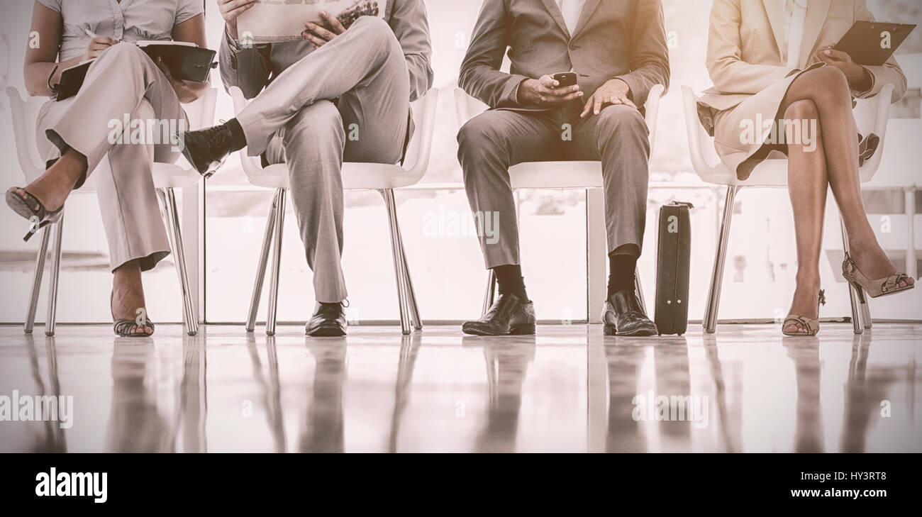 Low section of business people waiting in office Stock Photo - Alamy