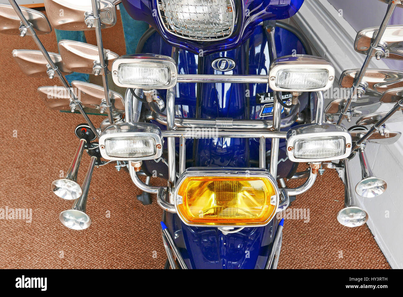 Chrome mirrors and lights on the front of a blue Lambretta scooter ...