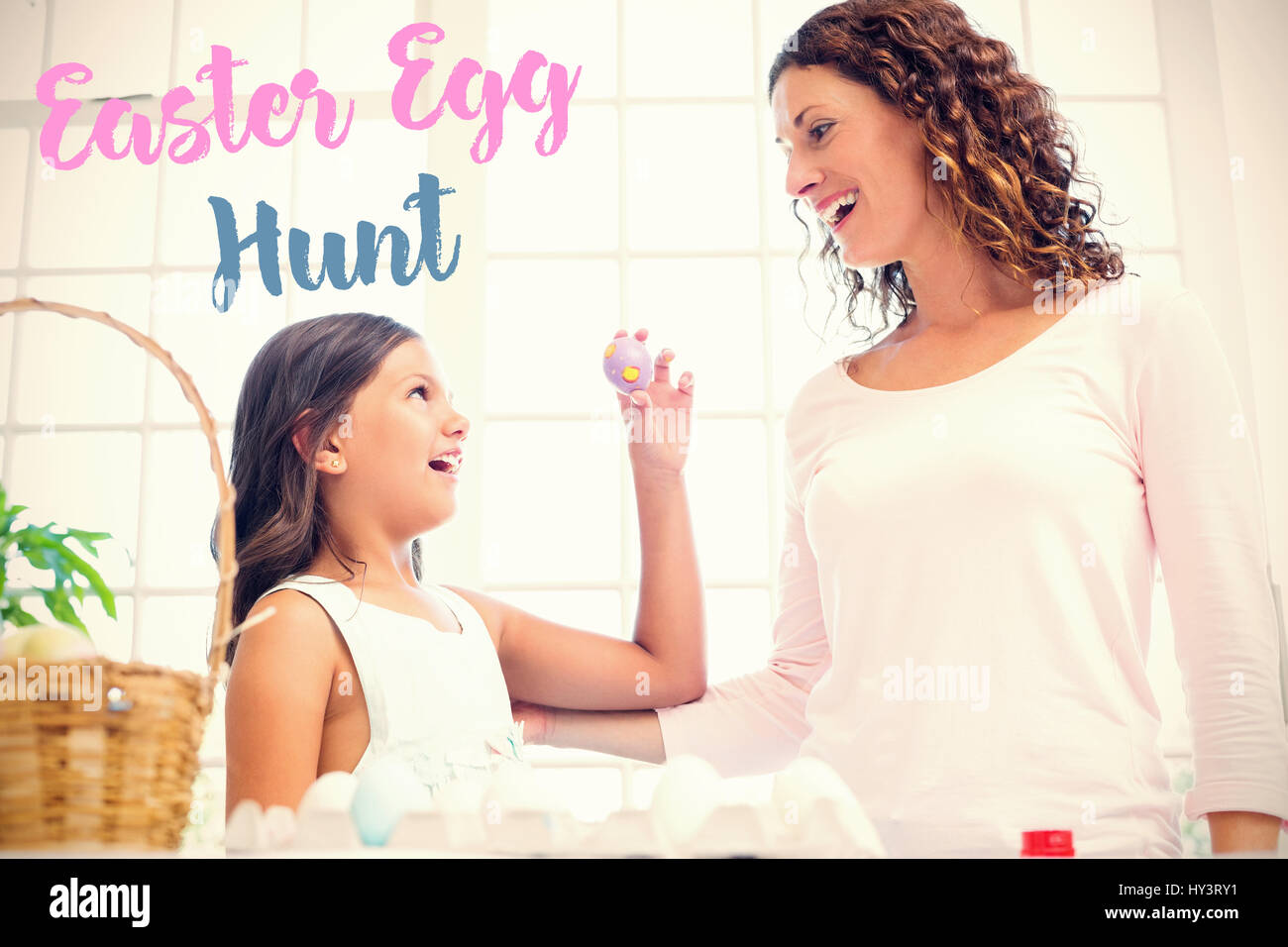 Happy girl showing easter egg to her mother against easter greeting ...