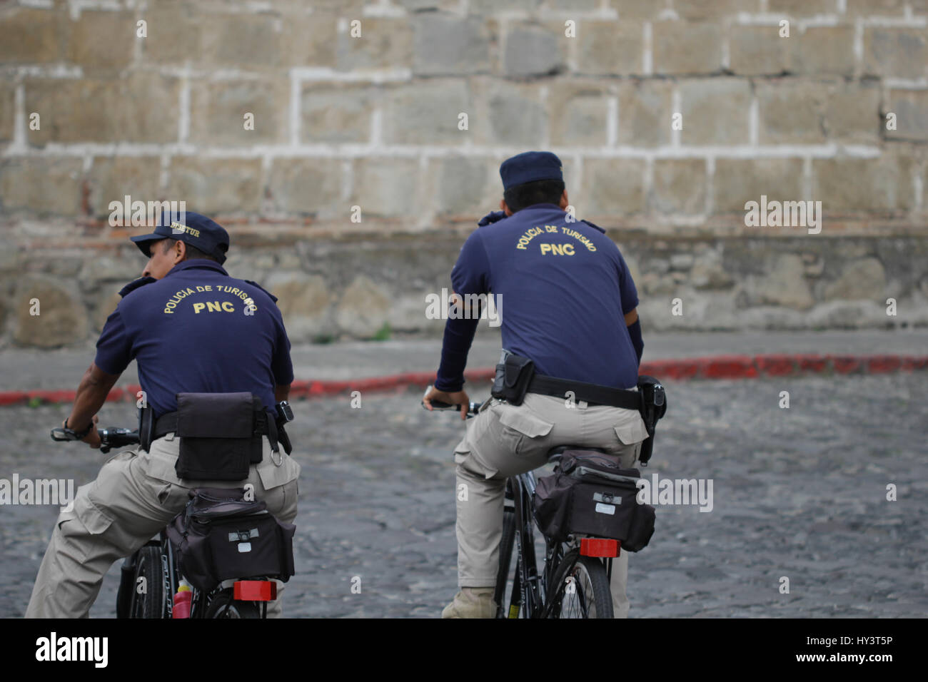 Police in blue official uniforms riding bicycles in Antigua Guatemala ...