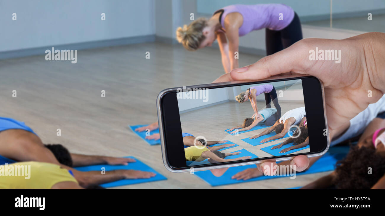 Hand holding mobile phone against white background against yoga ...