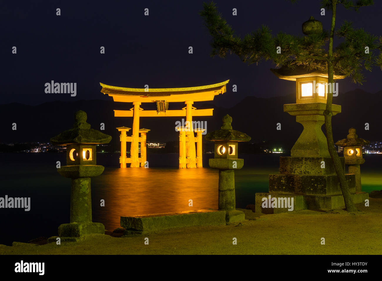 Illuminated floating Torii gate in background at night with illuminated ...
