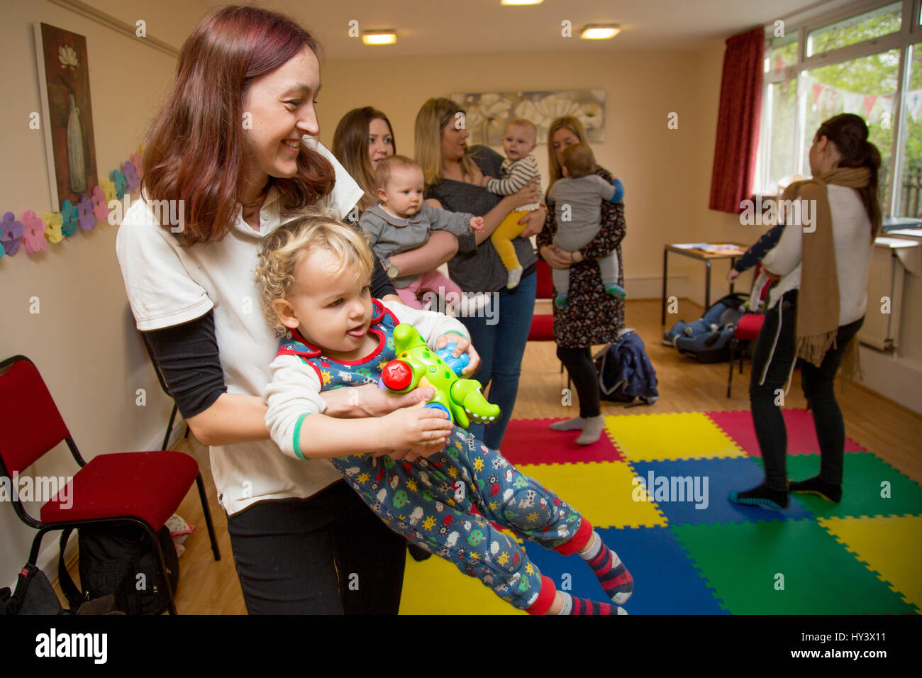 Parents singing songs with children at a playgroup Stock Photo - Alamy
