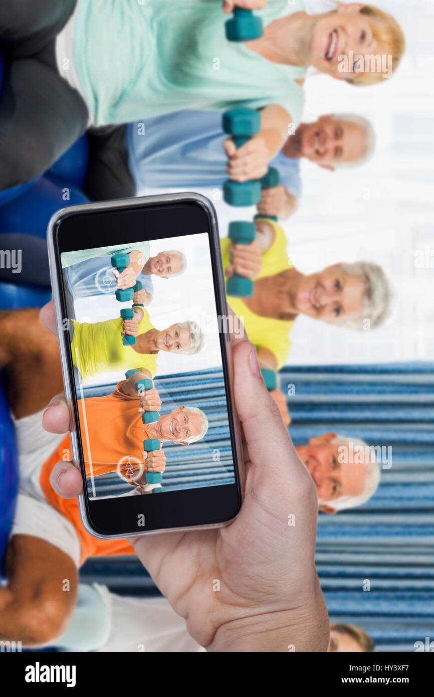 Hand holding mobile phone against white background against portrait of ...