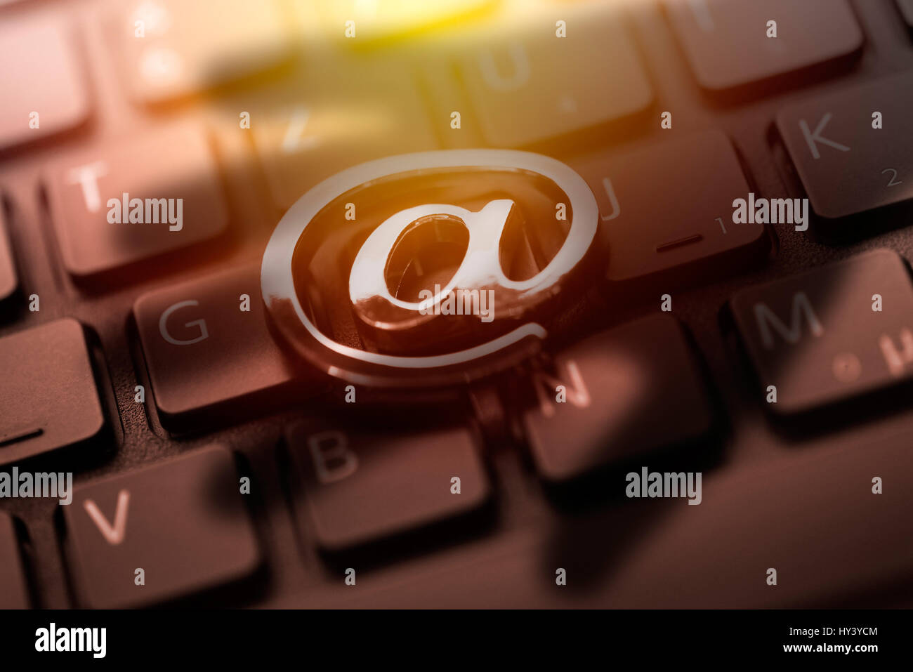 At-sign on computer keyboard with shade of a hand, symbolic photo ...