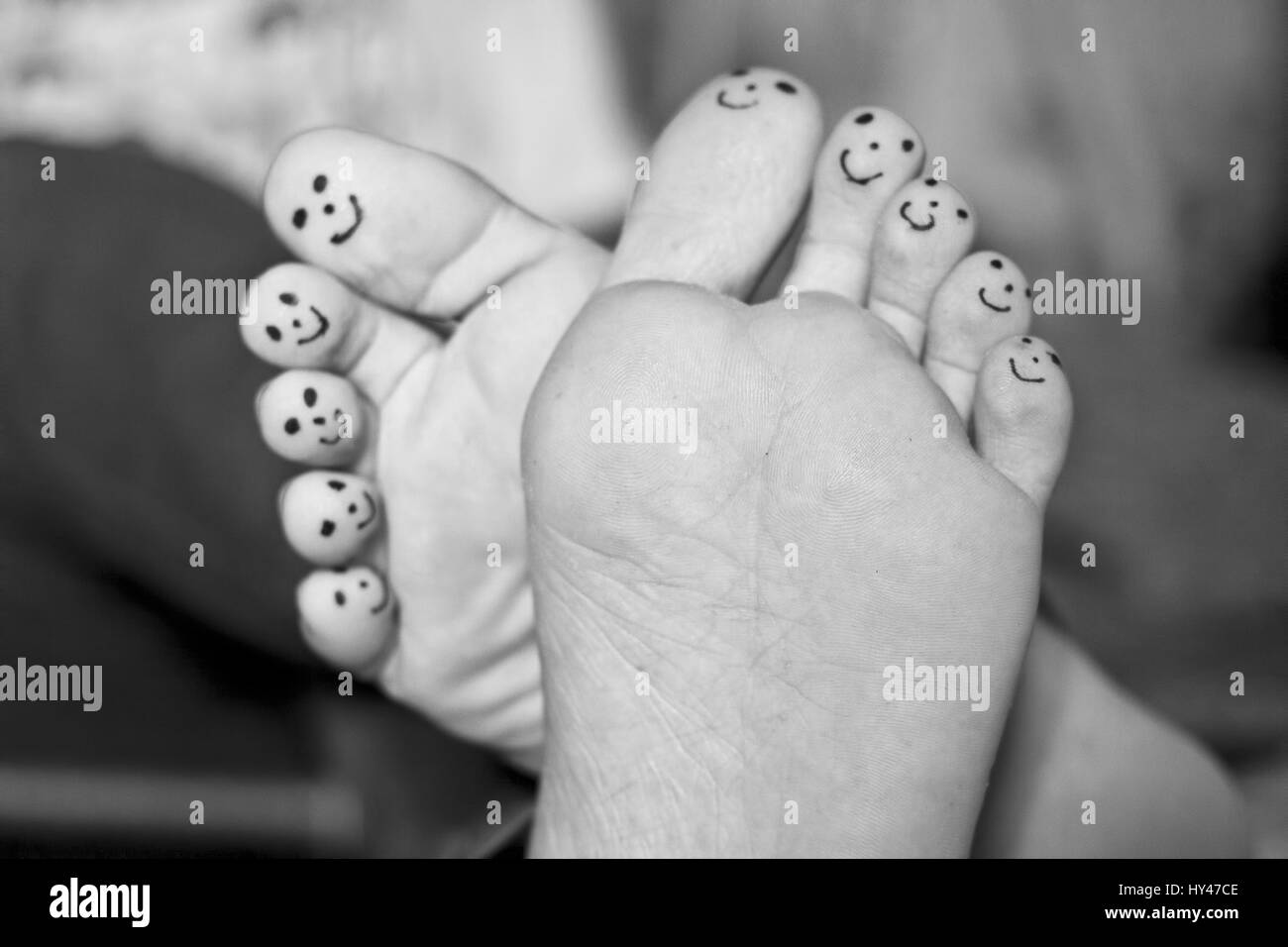 all ten toes of feet with smiley faces drawn with black pen Stock Photo ...