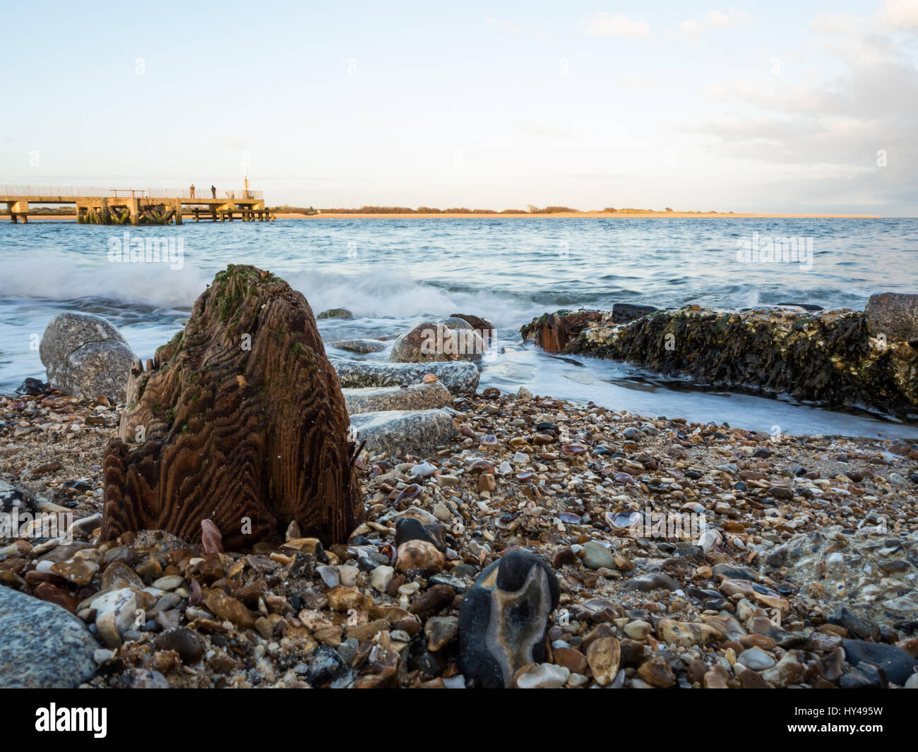 Evening on the beach with a worn post Stock Photo - Alamy