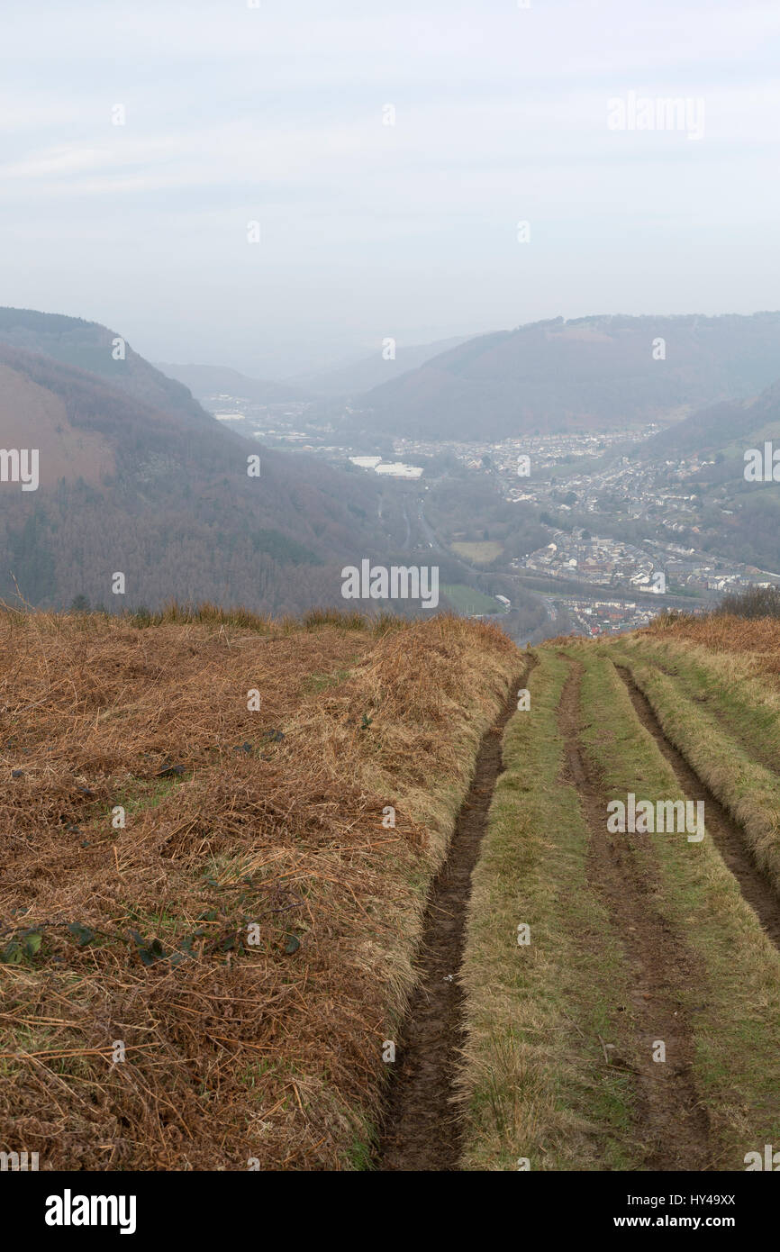 track on mountain disappears into valley below with houses Stock Photo ...