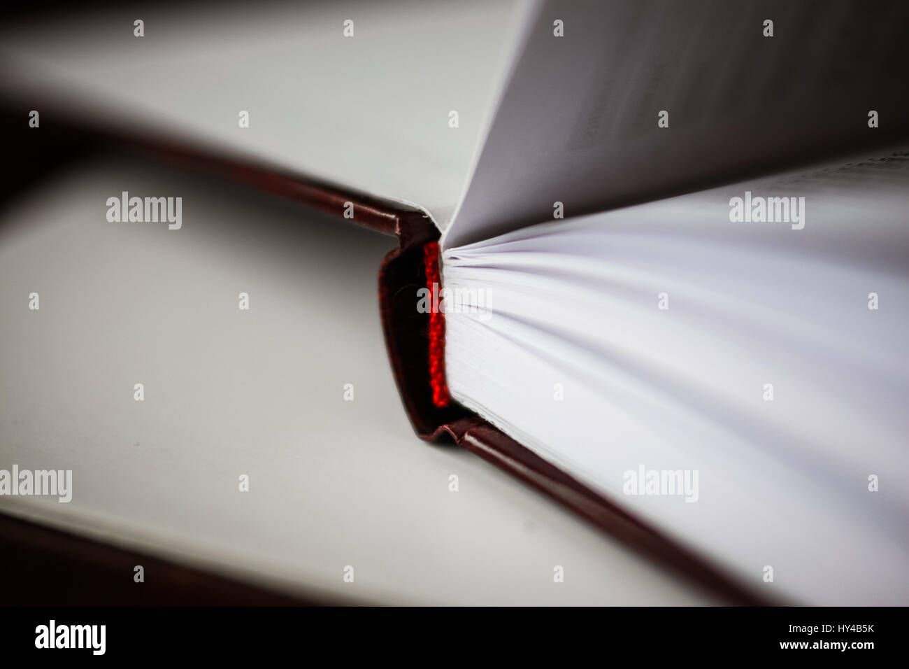 A beautiful closeup of a book in dark red cover and with red bookmark ...