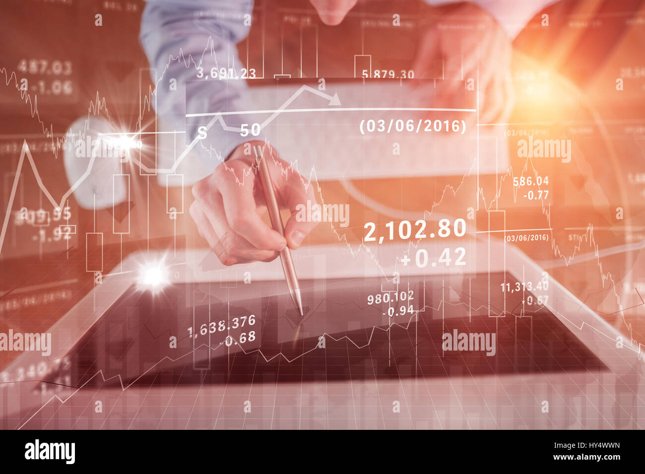 Businessman pointing to screen with pen against stocks and shares Stock ...
