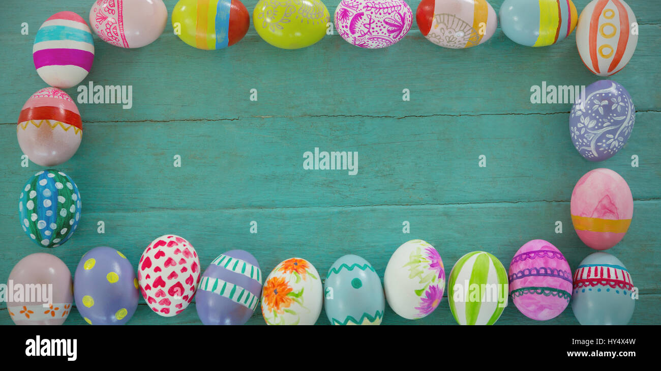 Overhead of painted Easter eggs arranged in rectangle shape on wooden ...