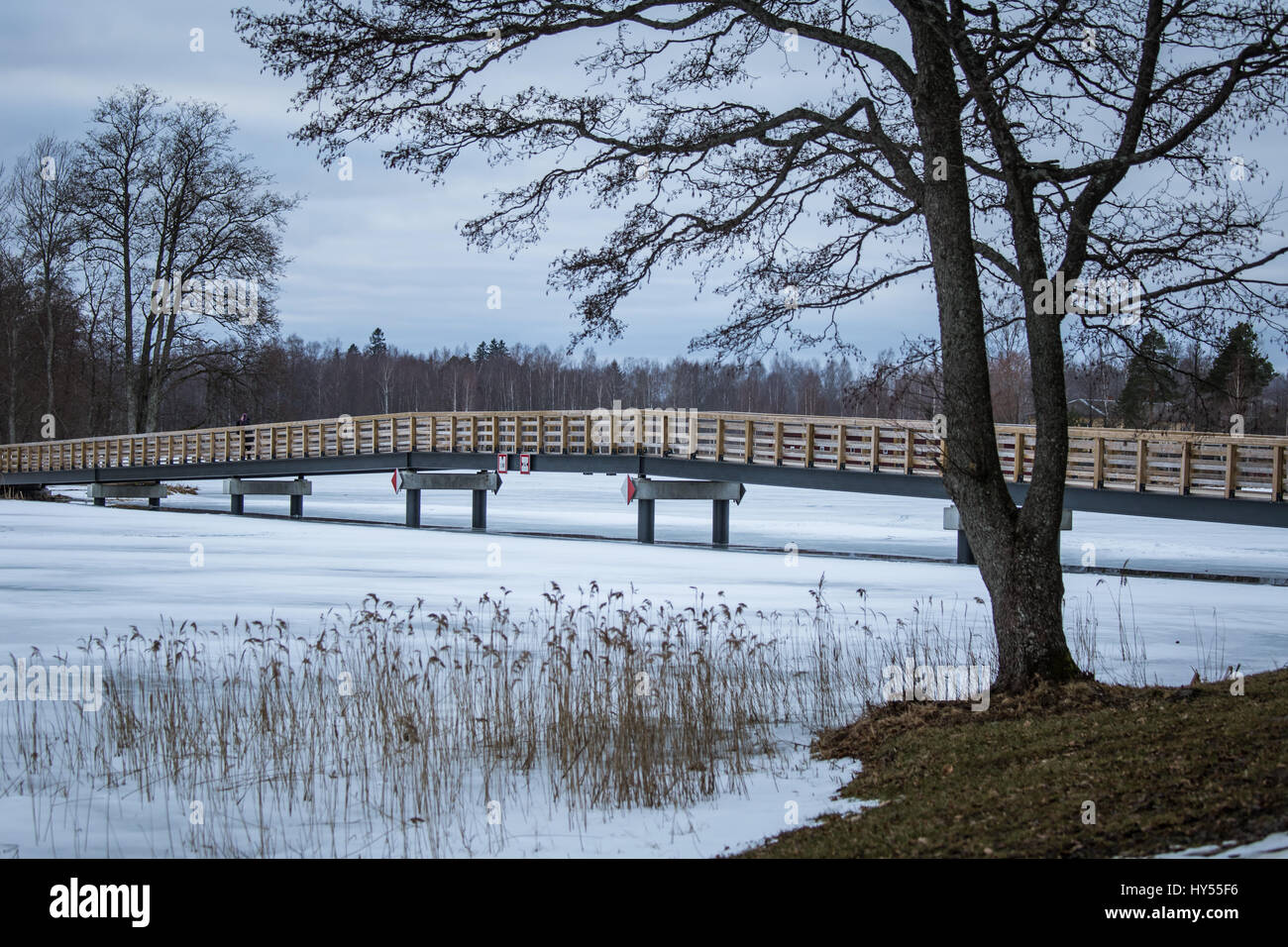 A beautiful winter landscape with a bridge over the frozen river Stock ...