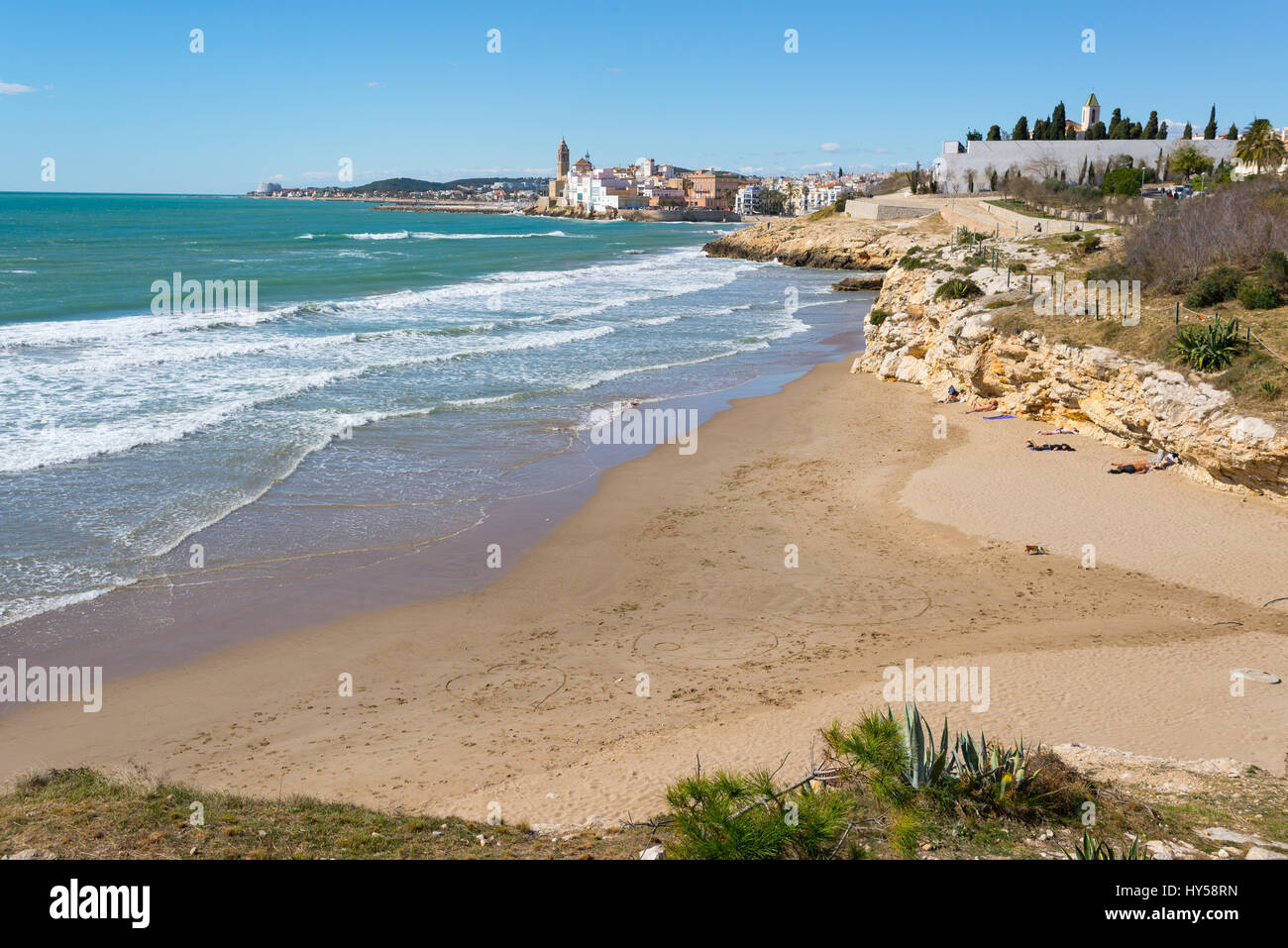 Beach and rocky coast with view of the beautiful town of Sitges, Spain ...