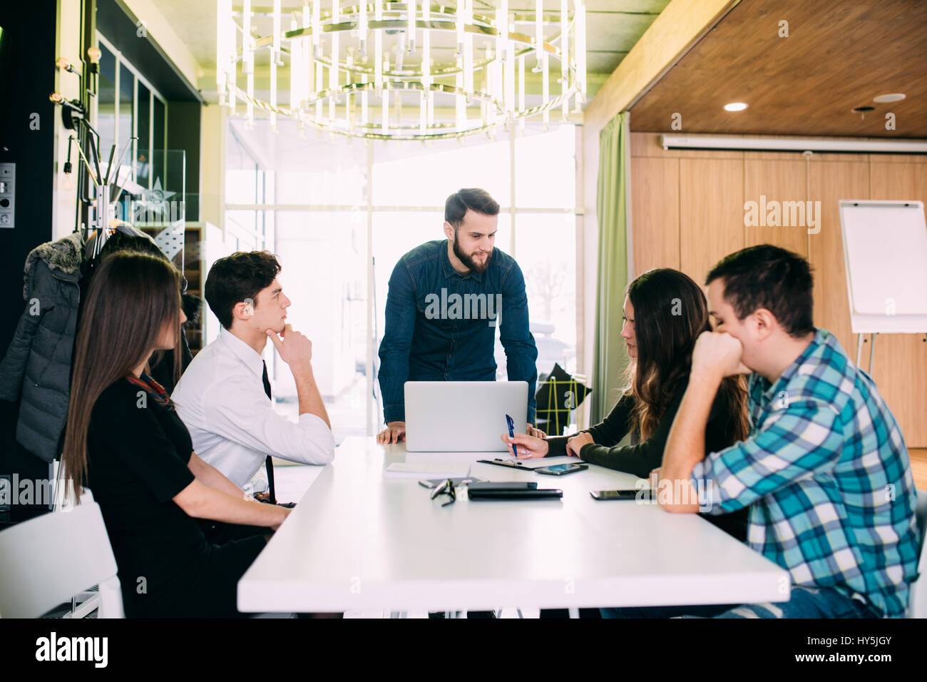Young freelance team meeting at table discuss goals in modern office ...