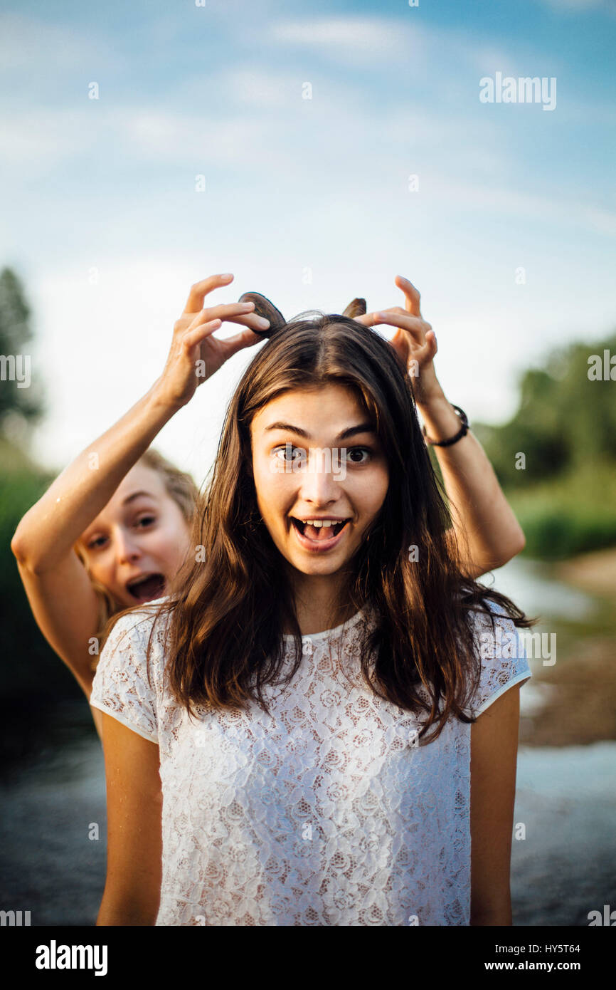 Two young women, having fun, silly, holding shells as ears Stock Photo ...