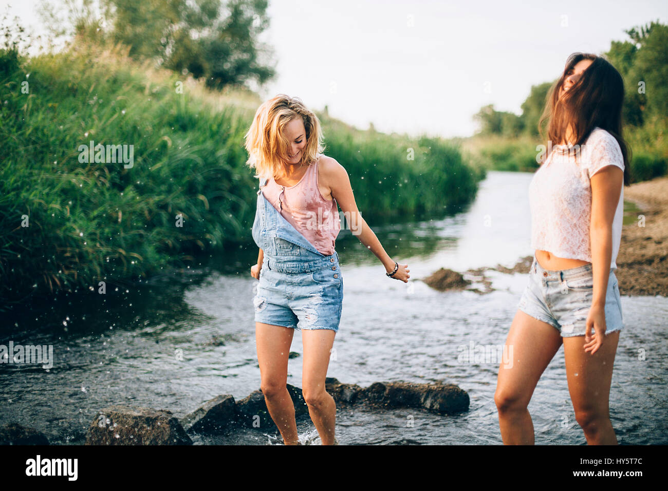 Two young woman dancing in a brook Stock Photo - Alamy