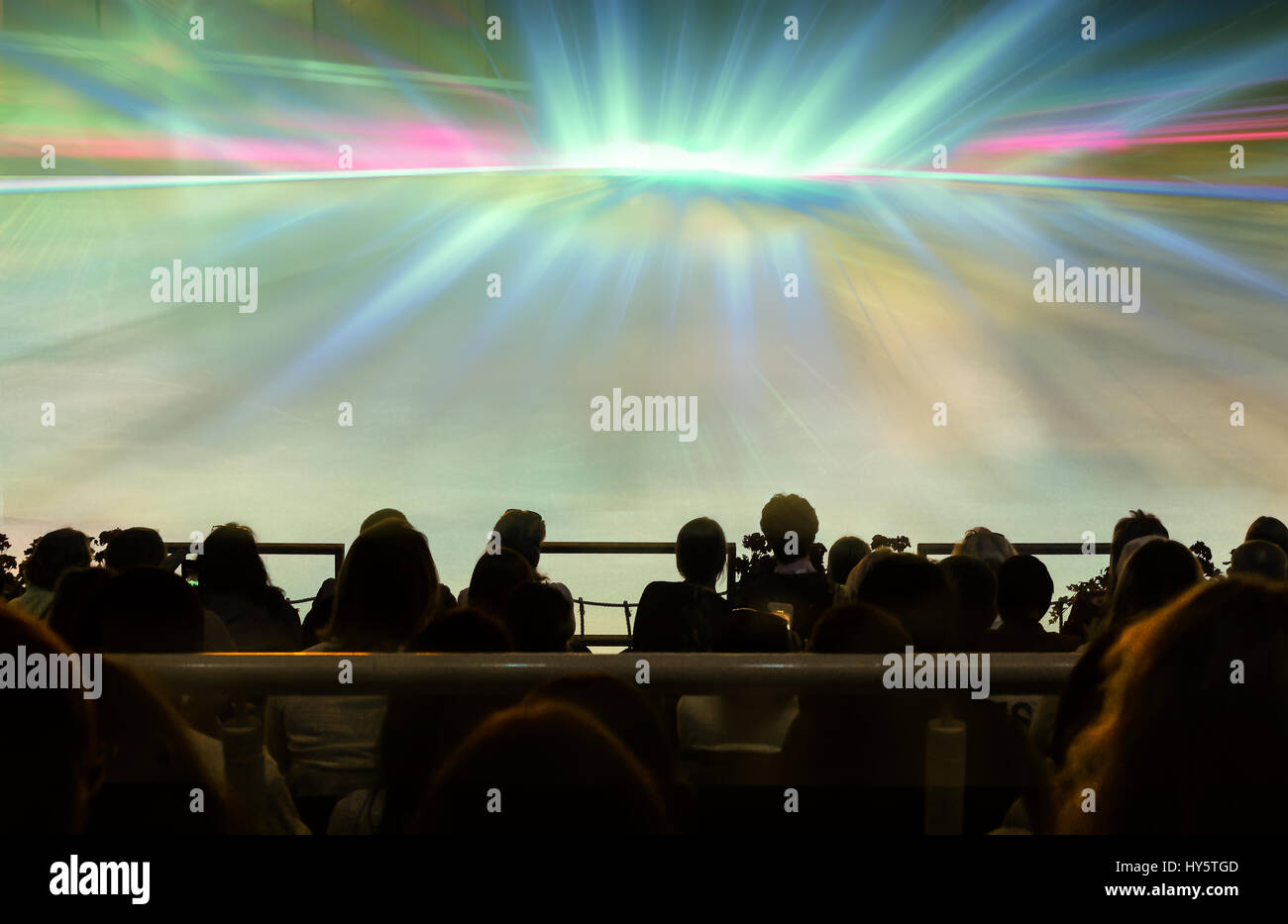 The audience in the brightly lit colored rays hall awaiting the start ...