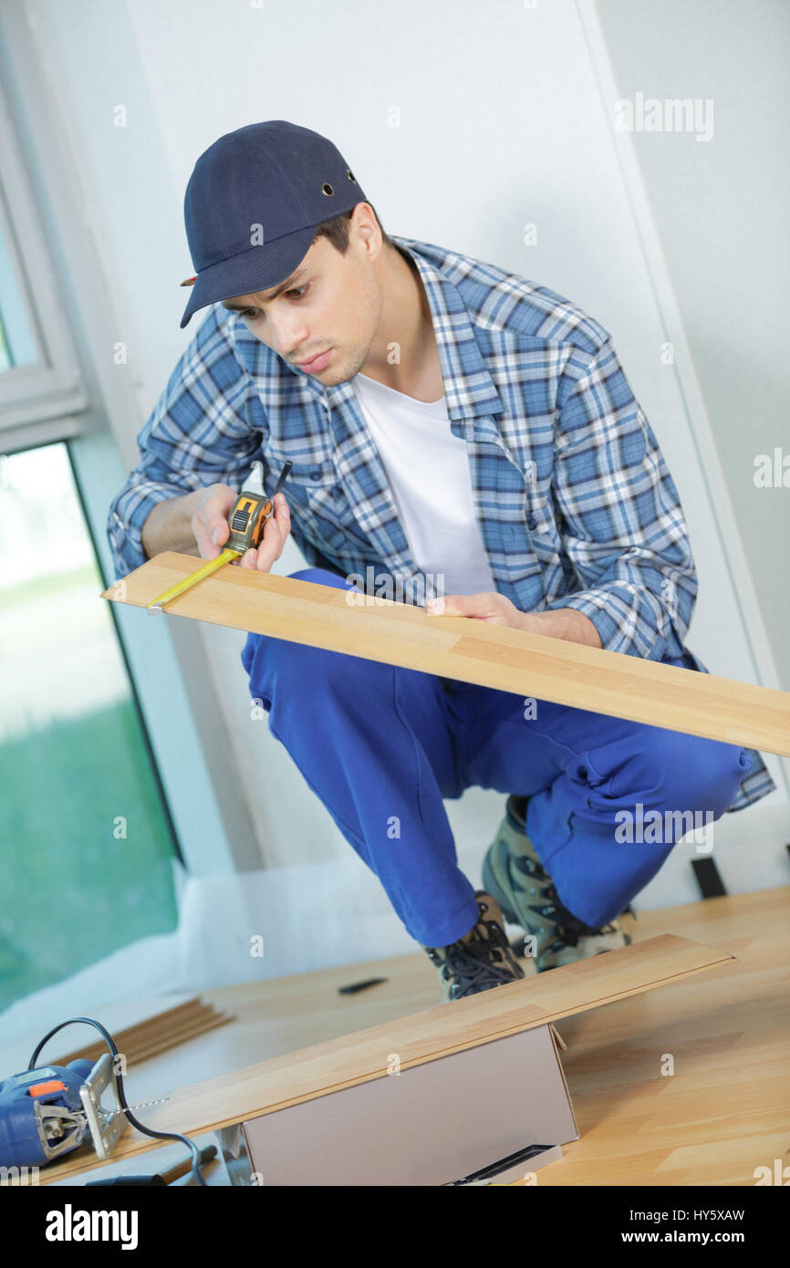 male handyman measuring wood Stock Photo - Alamy