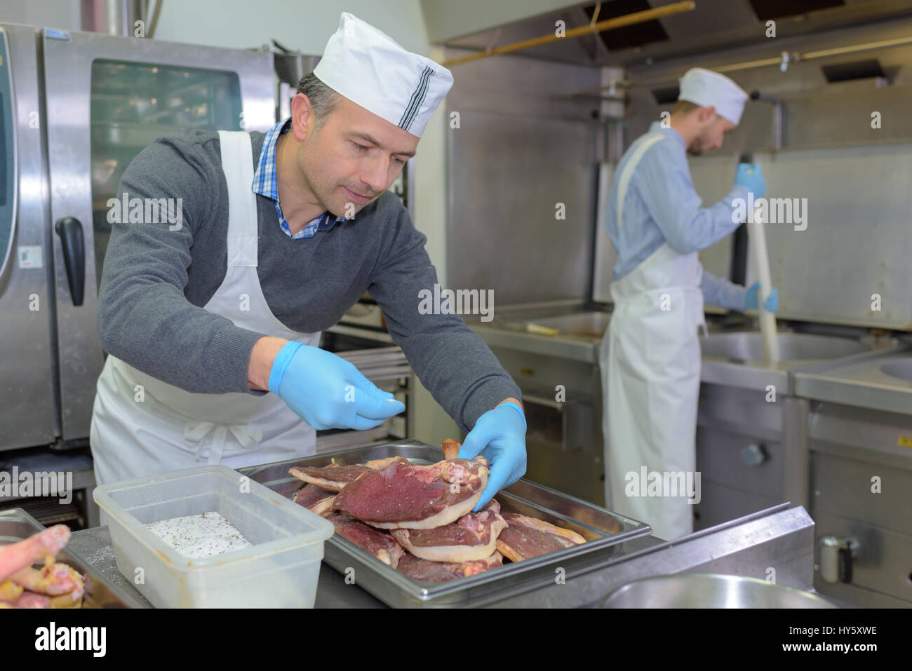 Chef seasoning cuts of meat Stock Photo - Alamy