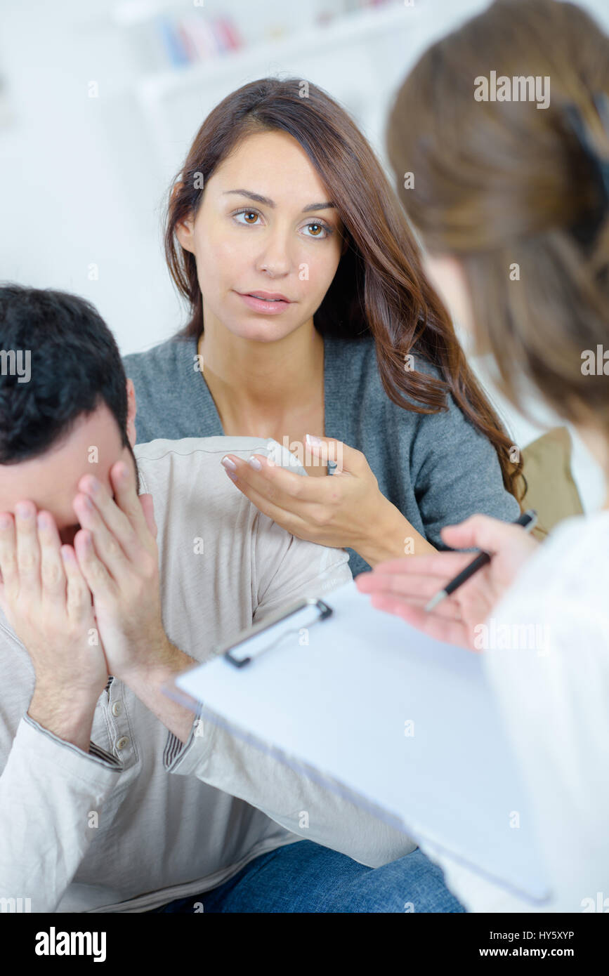 Woman assessing man in tears Stock Photo - Alamy