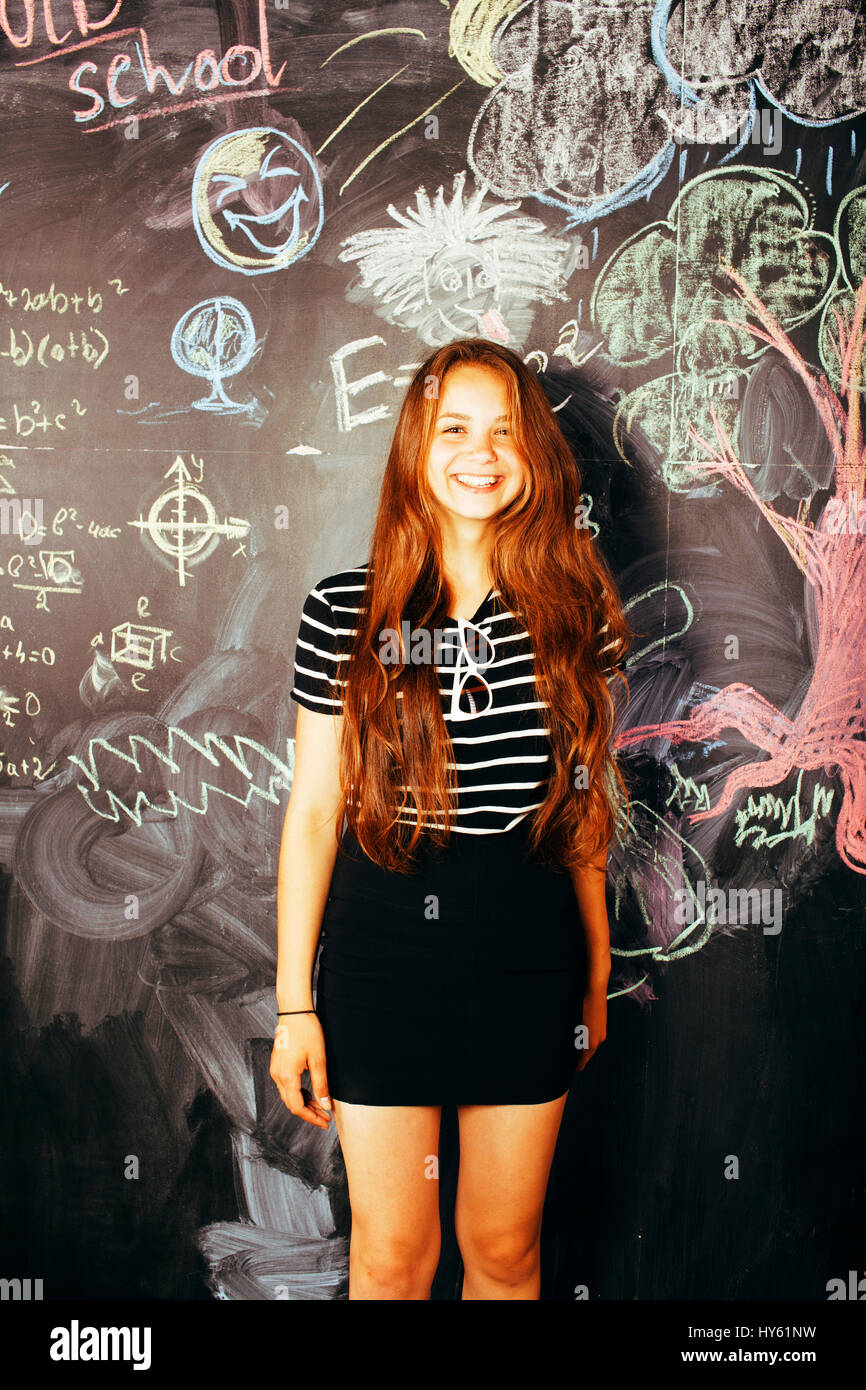 portrait of happy cute student in classroom at blackboard back to ...