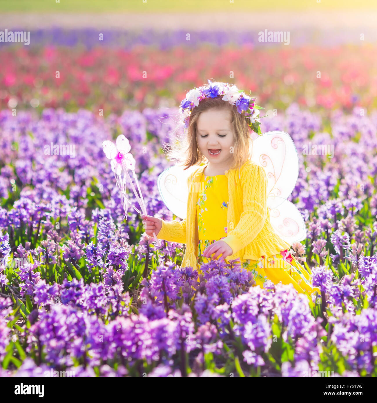 Beautiful girl playing in blooming hyacinth flower field. Kids princess ...