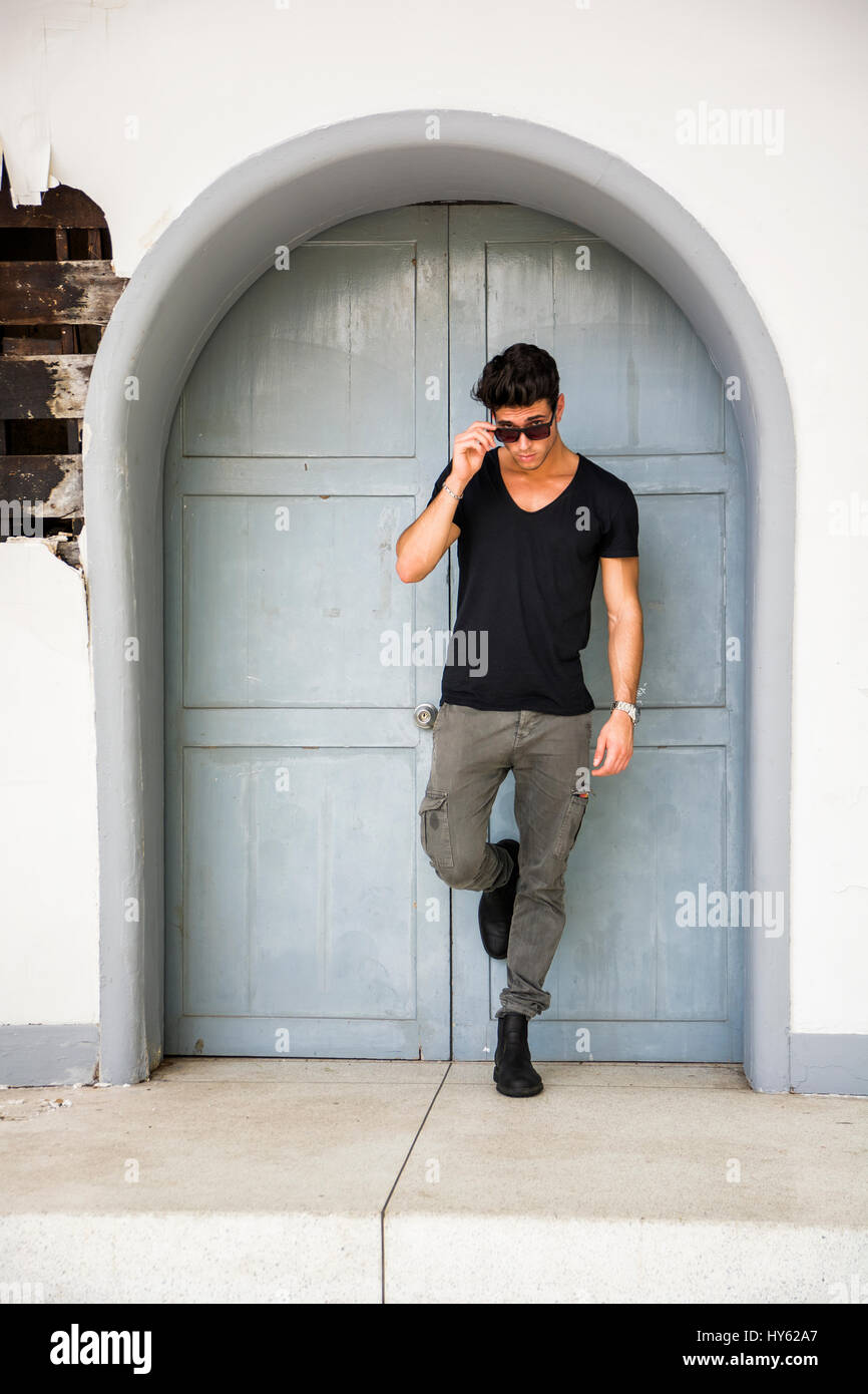 Handsome young man in front of wood door Stock Photo - Alamy