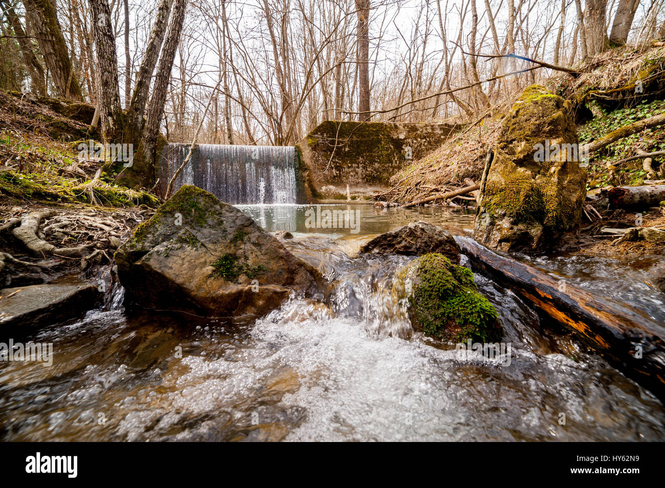 Small stream with waterfall flowing in a forest with big stones and ...