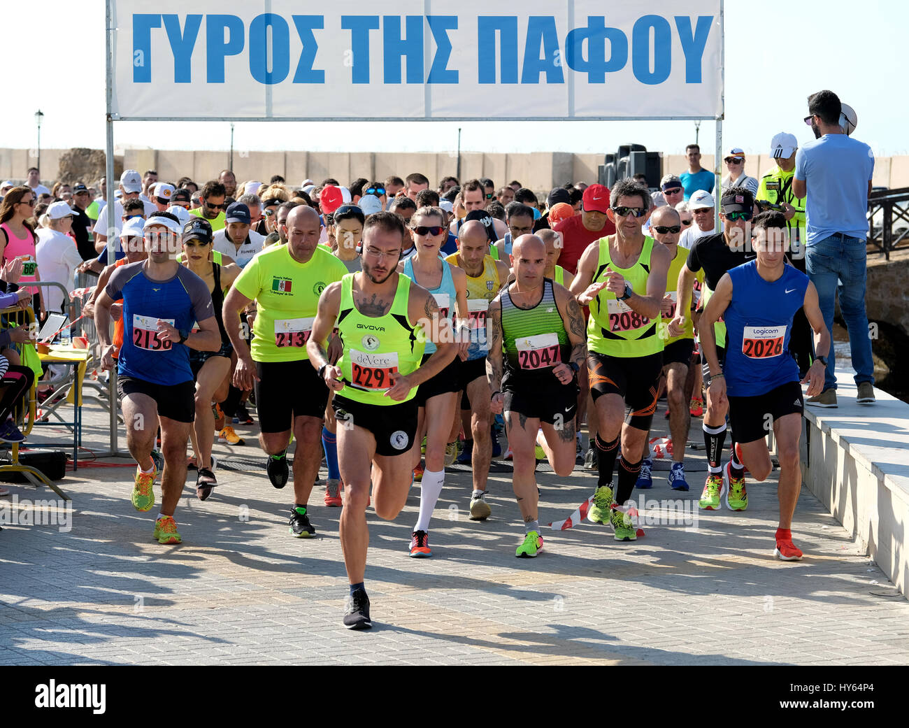 Athletes leave the start of the 10k road race in front of Paphos Castle ...