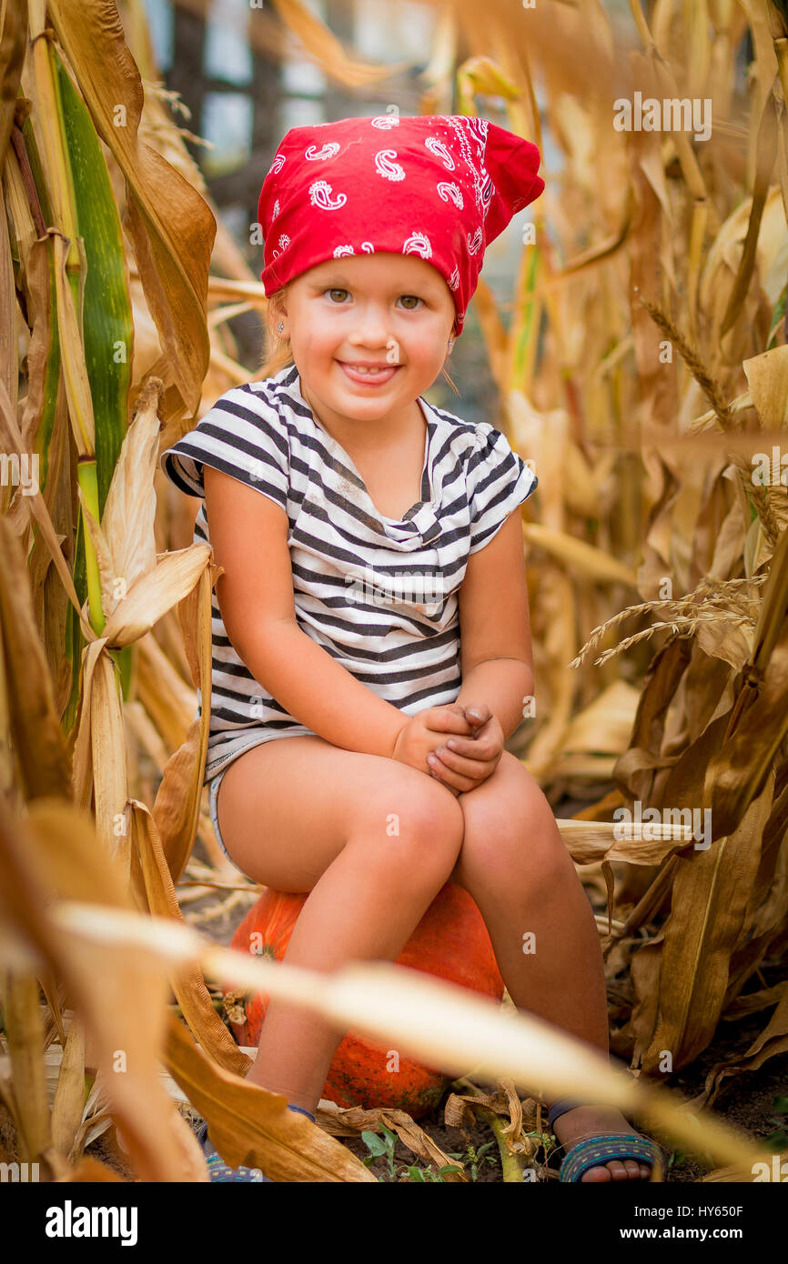 Happy child in red bandana and stripe tee showing tongue and sits on a ...