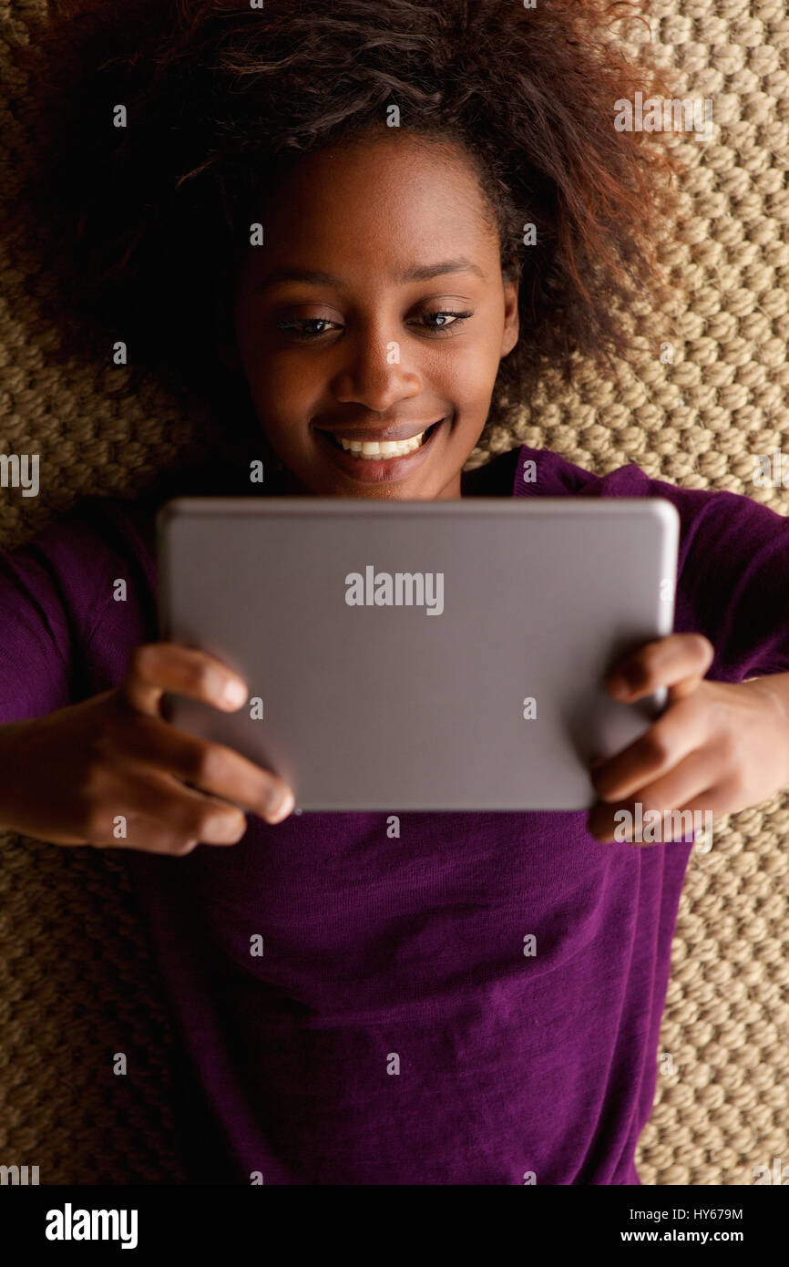 Portrait from above african woman lying down with digital tablet Stock ...