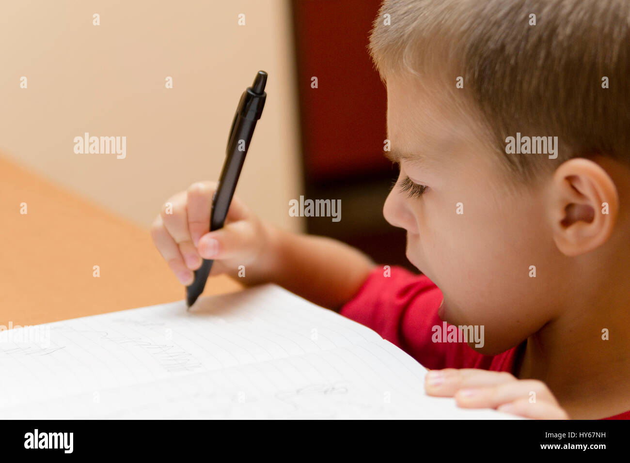 Beautiful kid writing his first signs Stock Photo - Alamy