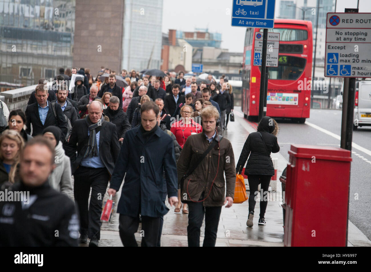 Crowds of commuters city workers, crossing London bridge during morning ...