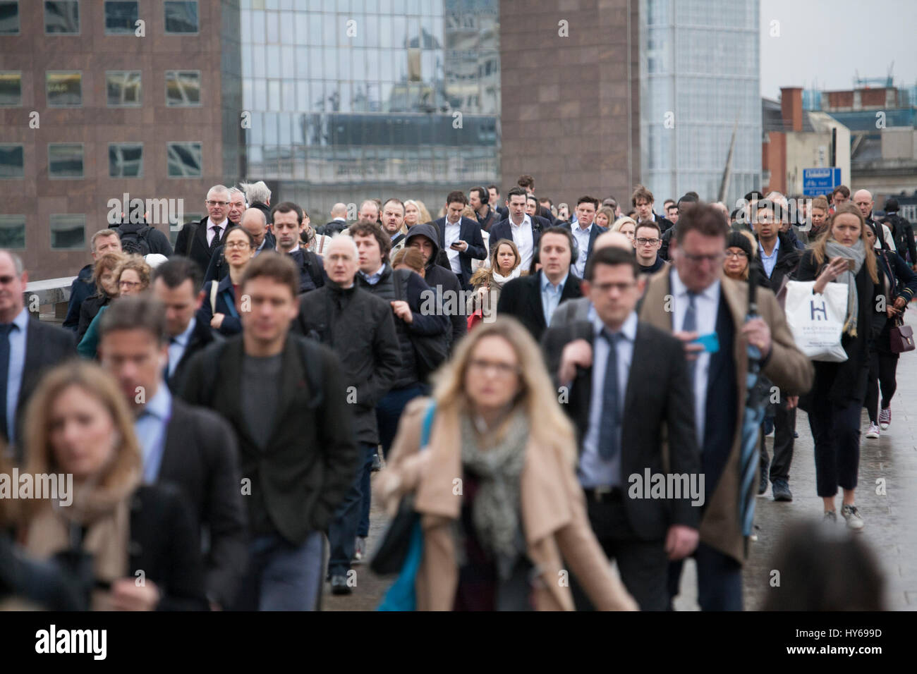 Crowds of commuters city workers, crossing London bridge during morning ...