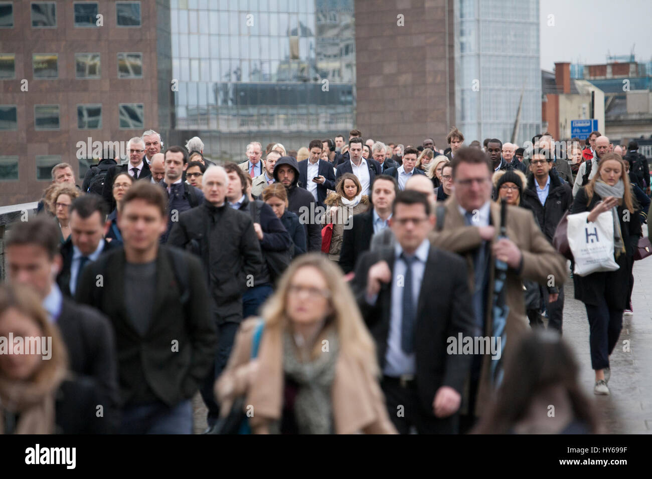 Crowds of commuters city workers, crossing London bridge during morning ...