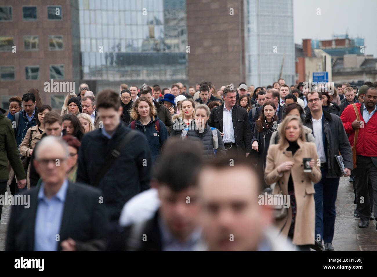 Crowds of commuters city workers, crossing London bridge during morning ...