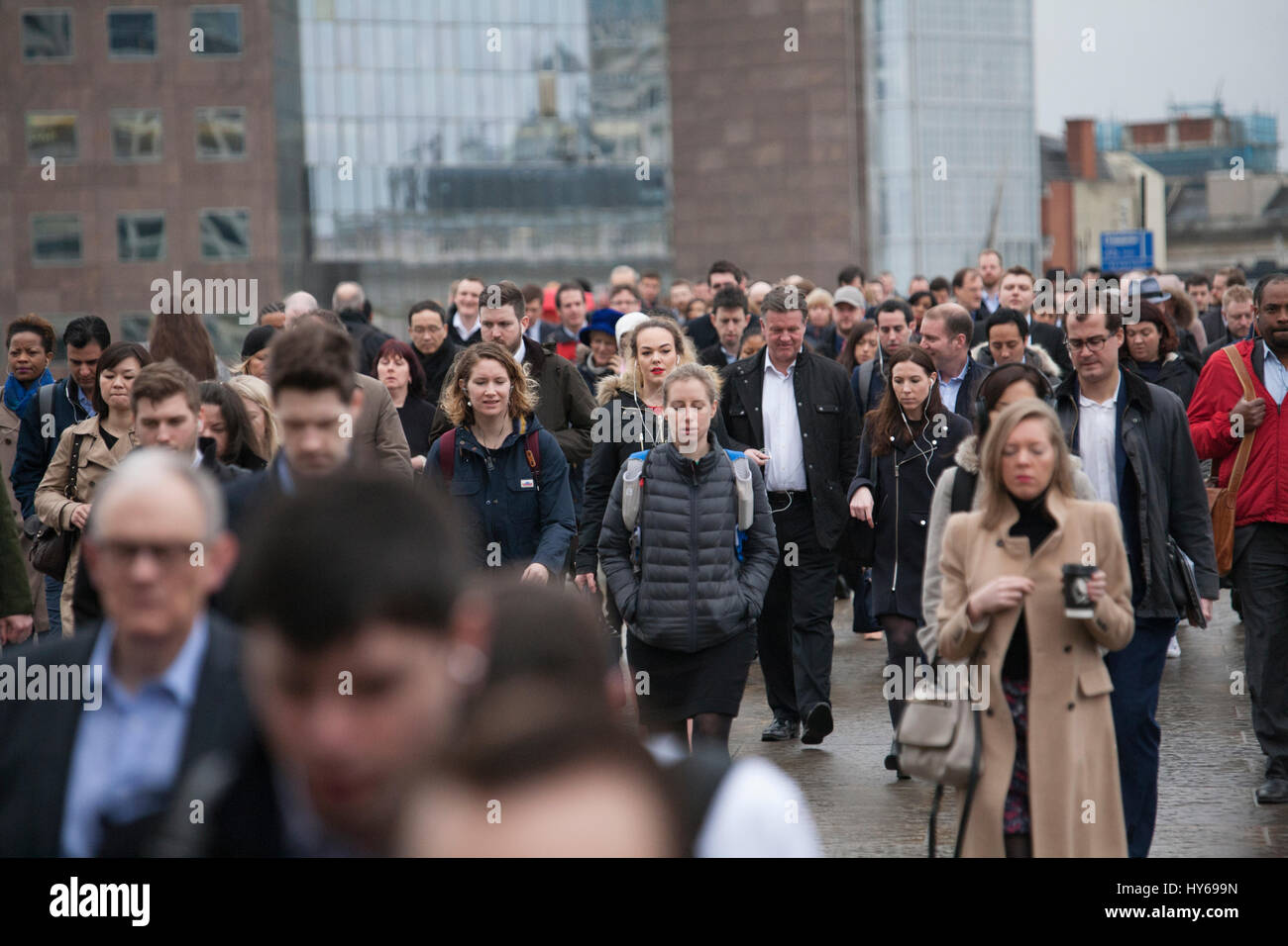 Crowds of commuters city workers, crossing London bridge during morning ...