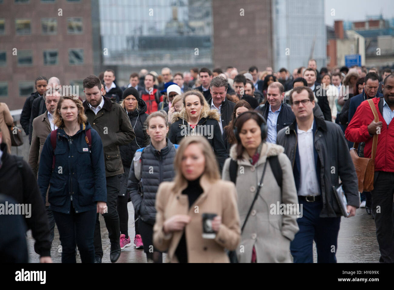 Crowds of commuters city workers, crossing London bridge during morning ...