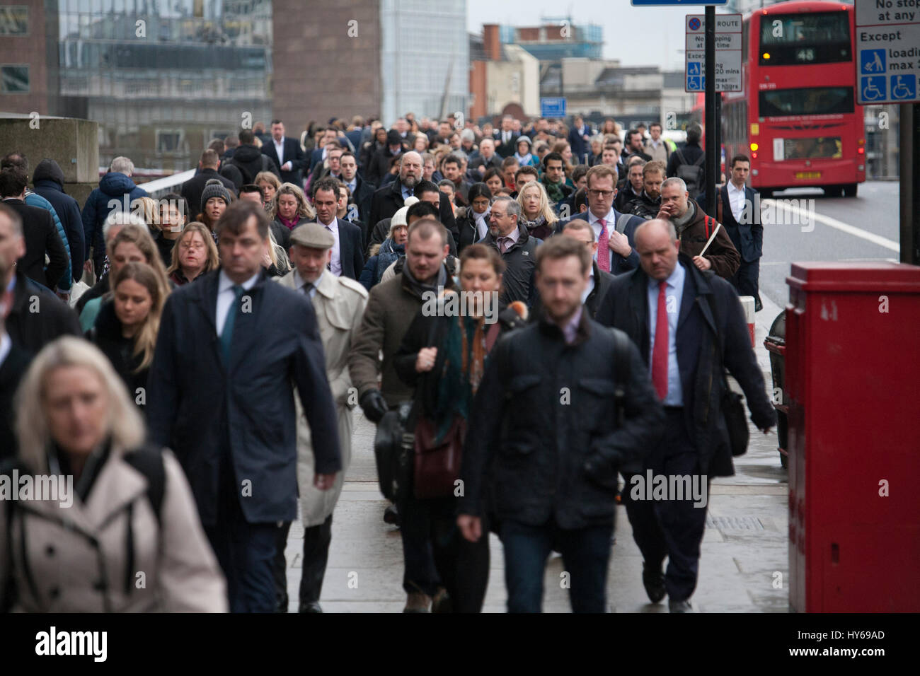 Crowds of commuters city workers, crossing London bridge during morning ...