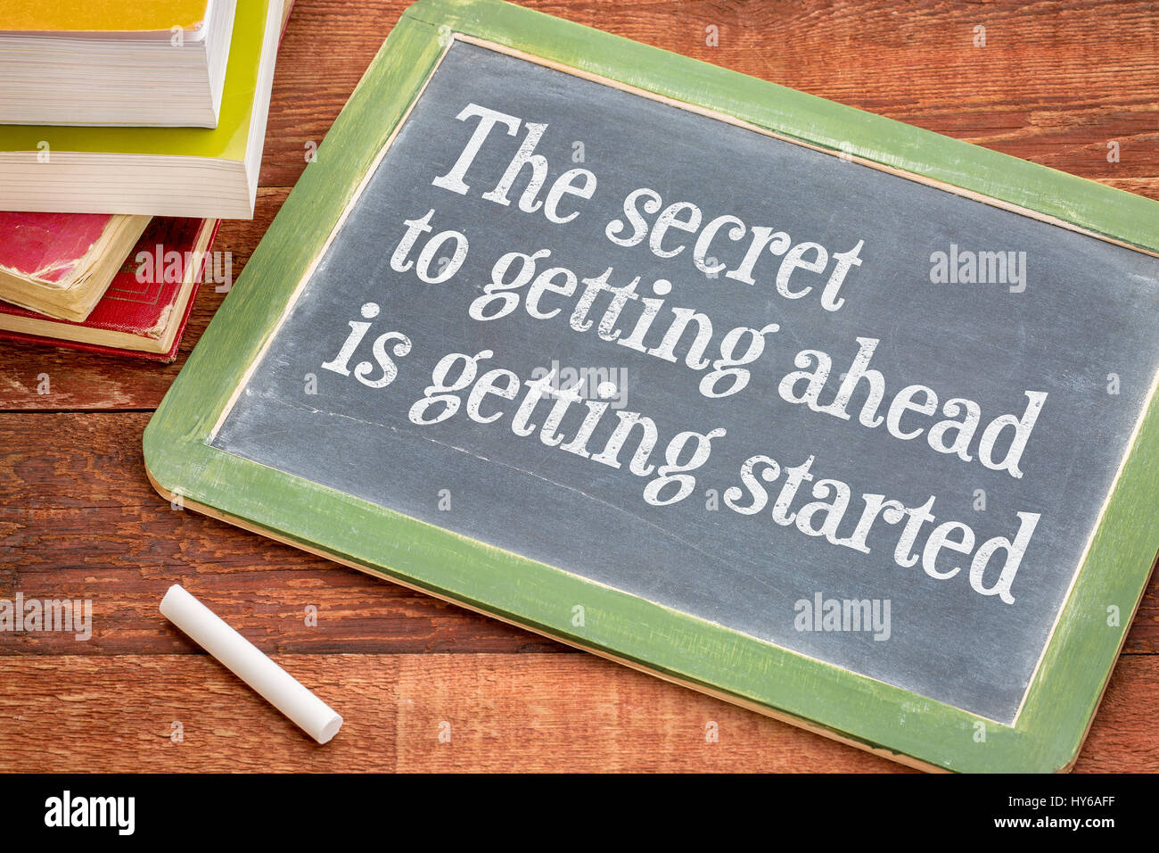 The secret to getting ahead is getting started - white chalk text on a ...