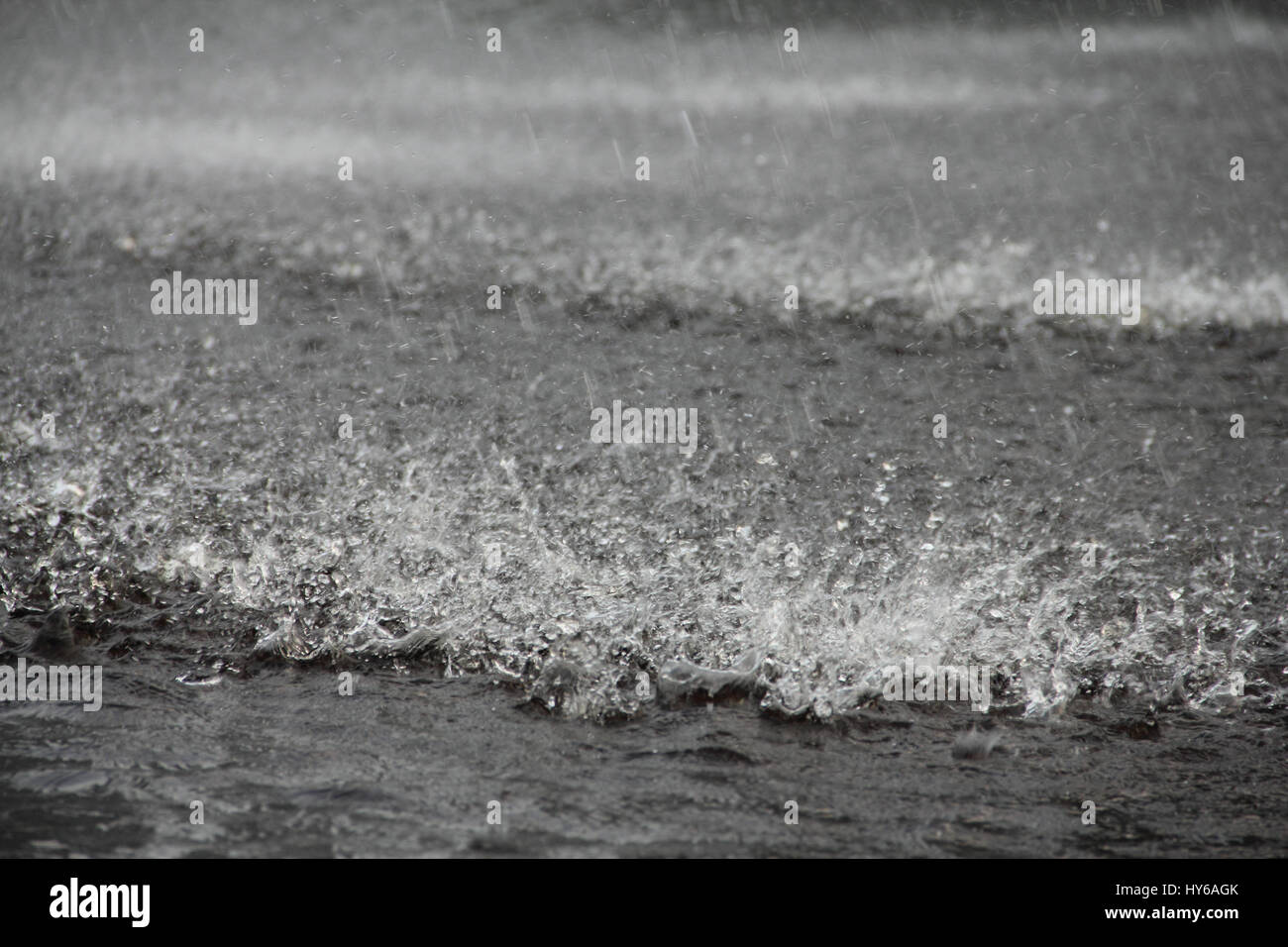 Heavy rain on ground, water drops splashing on water surface Stock ...
