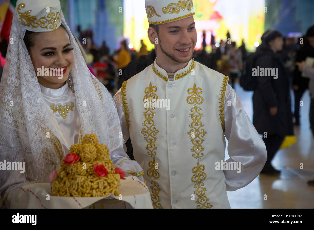 Couple in national tatar clothes with tatar national dish chak-chak ...