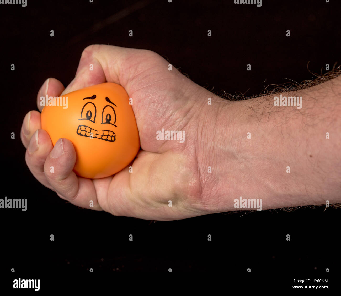 Orange Scary stress squeezed by a hand Stock Photo - Alamy